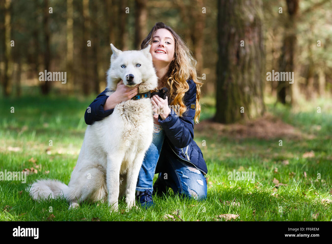 Happy young girl embracing husky dog in a forest at spring time Stock ...