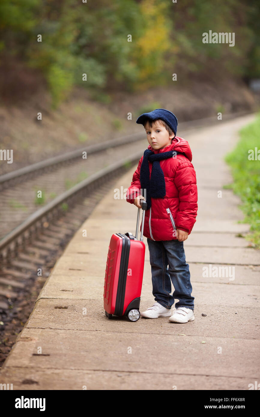 Adorable cute little child, boy, waiting on a railway station for a ...