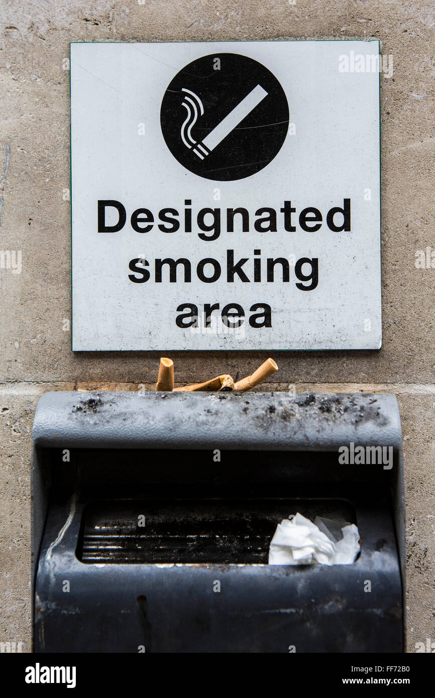 Designated smoking area sign and ash tray. Outside an office building ...