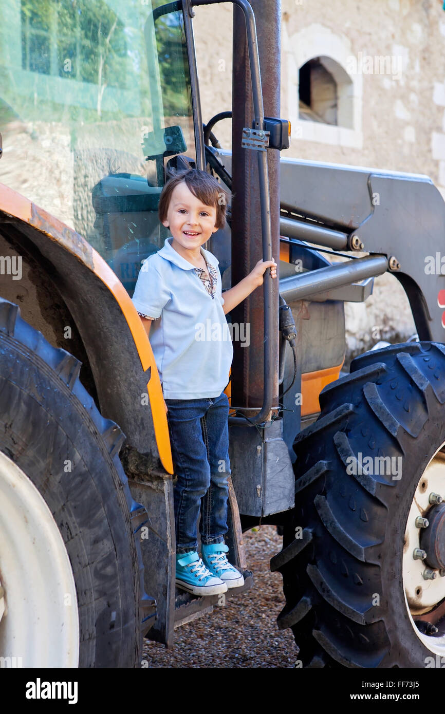 Portrait of little smiling boy in tractor in summer, outdoors Stock ...