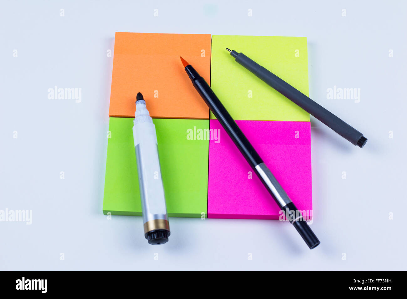 Square of colored sticky note with pens and markers on top Stock Photo ...