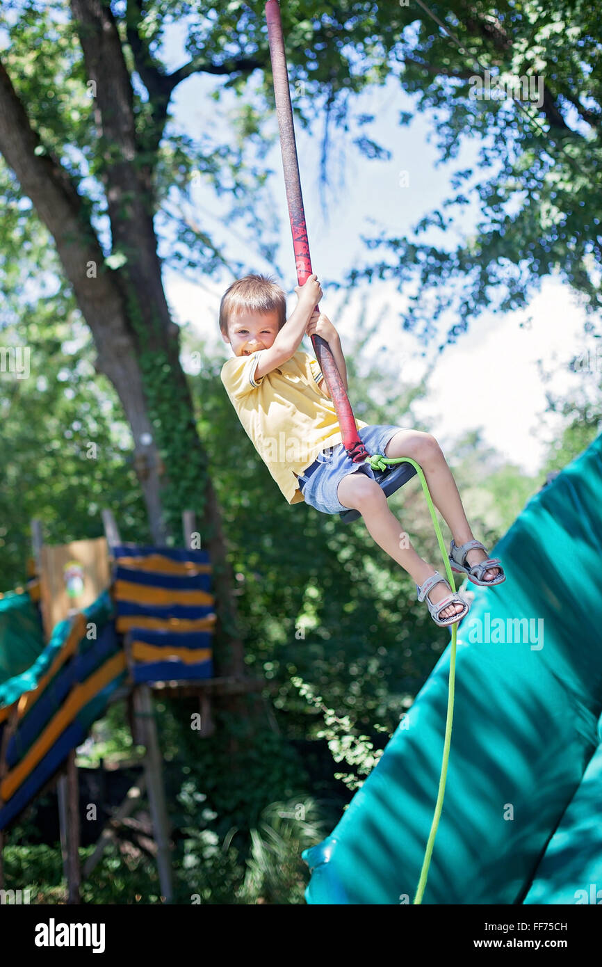 Cute child, boy, rides on Flying Fox play equipment in a children's ...