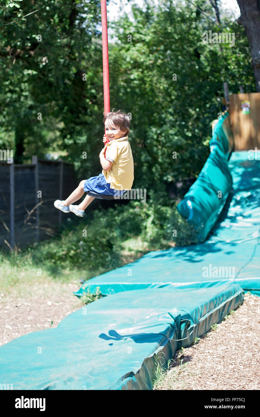 Cute child, boy, rides on Flying Fox play equipment in a children's ...