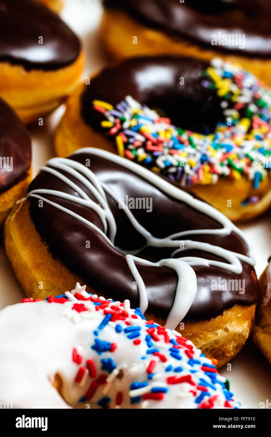 Assorted doughnuts in a vertical row close up Stock Photo - Alamy