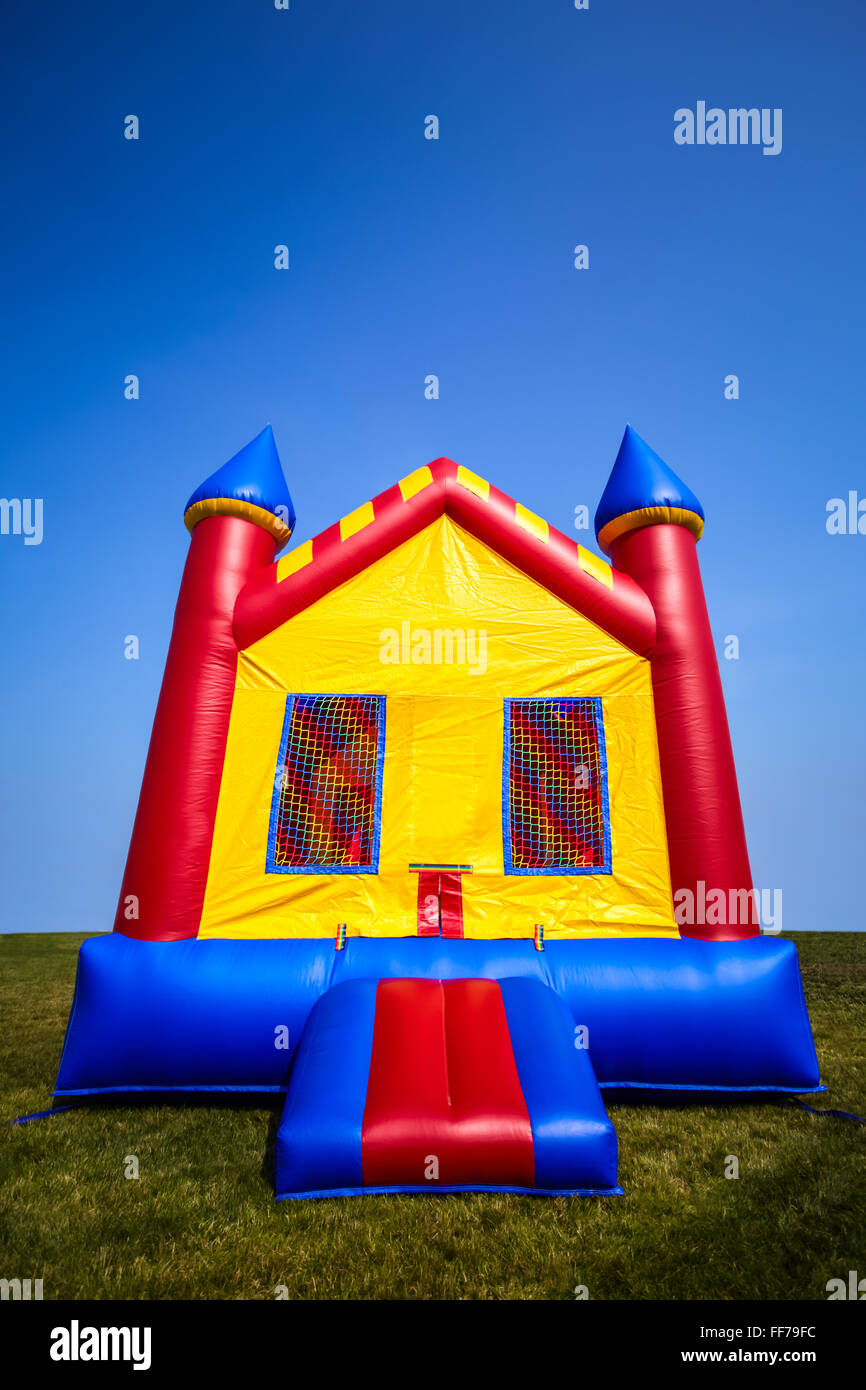 Children's inflatable bouncy castle house in a yard for a fun summer ...