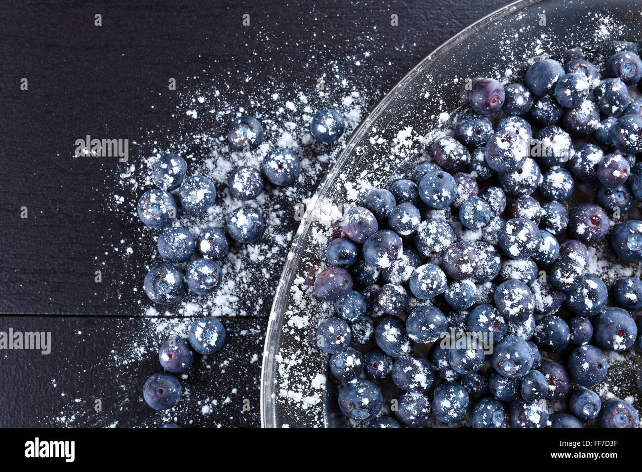 blueberry with sugar on a black table Stock Photo - Alamy
