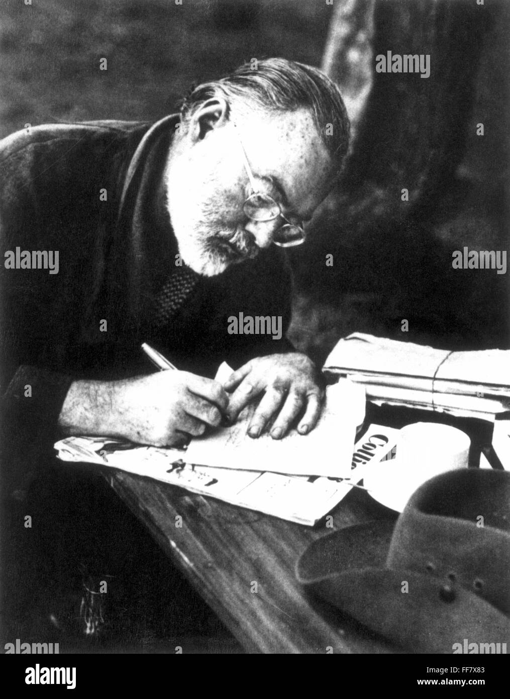 ERNEST HEMINGWAY /n(1899-1961). American writer. Writing while on ...