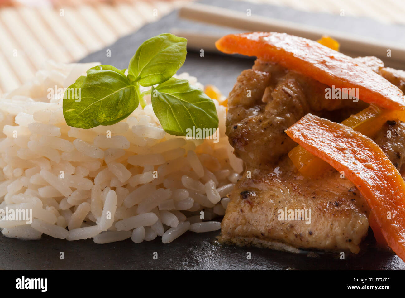 asian chicken dish on slate plate with rice Stock Photo - Alamy
