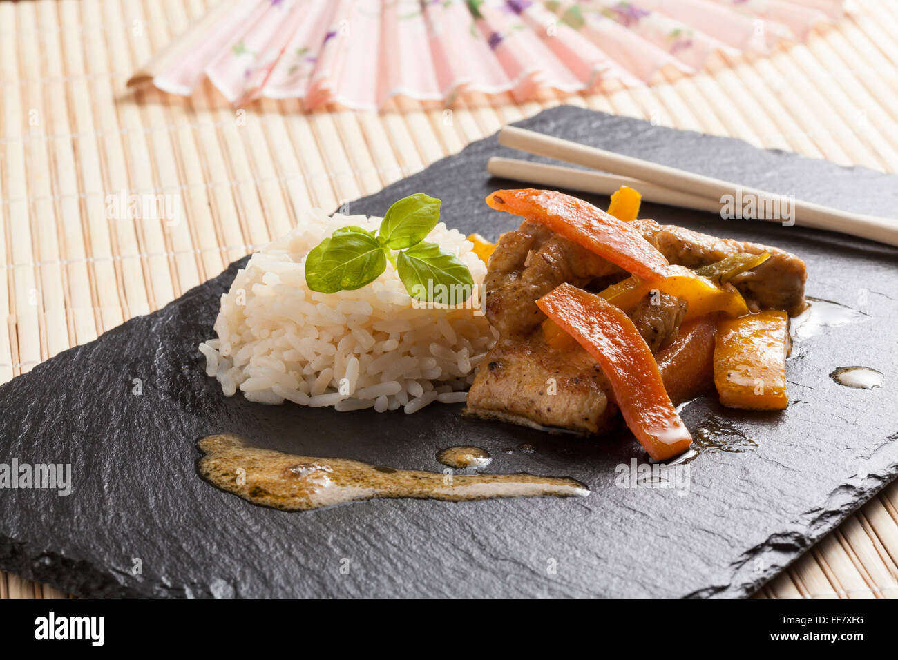 asian chicken dish on slate plate with rice Stock Photo - Alamy