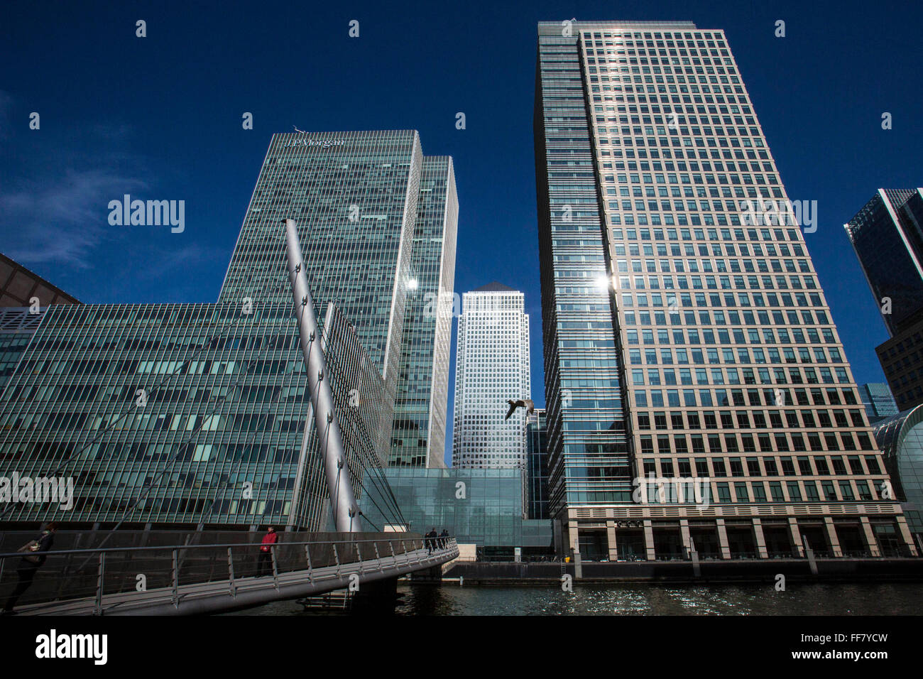 Commuters walk across the South Quay footbridge over the South Dock on ...