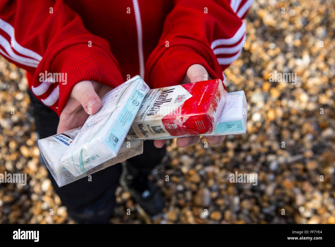 A person holds a packet of wet cigarettes in their hand. The cigarette ...