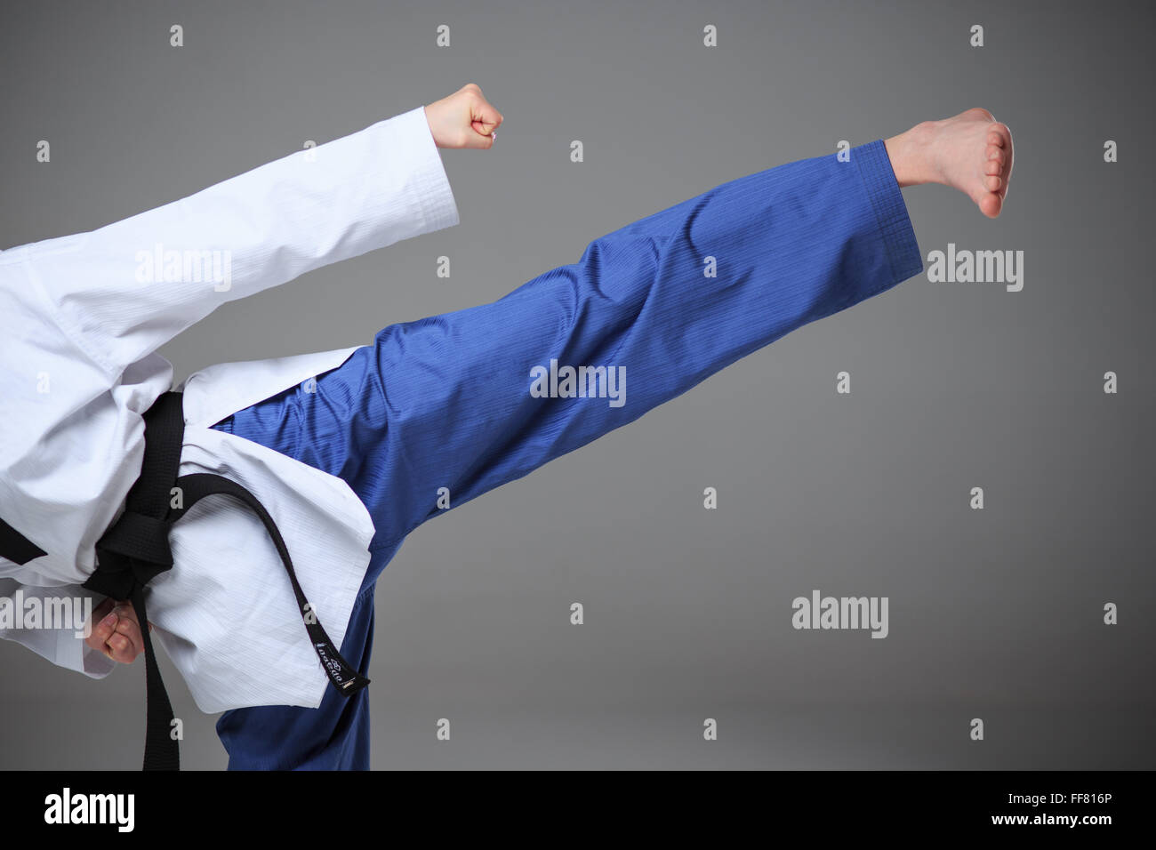 The hand and foot of karate girl in white kimono and black belt ...