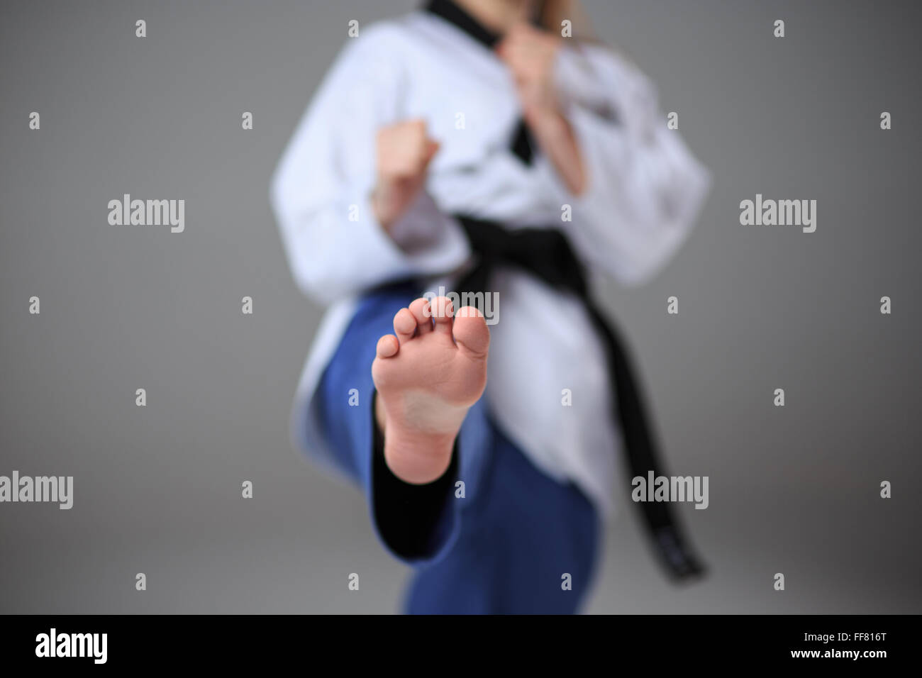 The foot of karate girl in white kimono and black belt training karate ...
