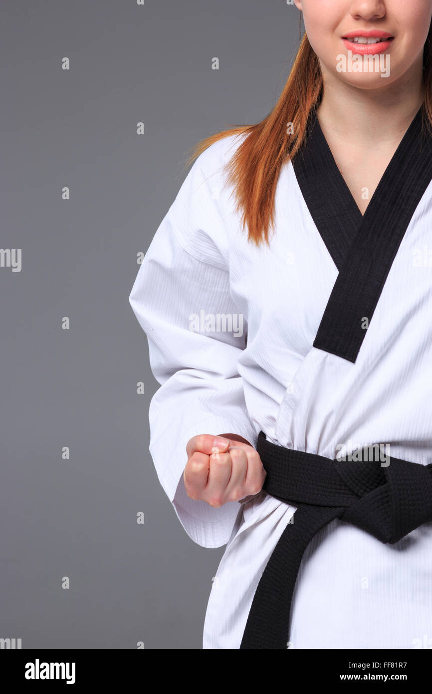 The hand of karate girl in white kimono and black belt training karate ...