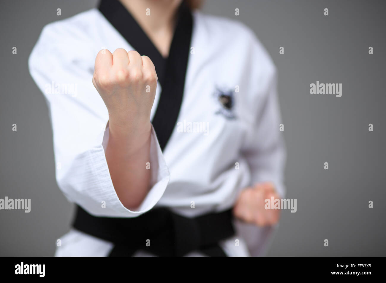 The hand of karate girl in white kimono and black belt training karate ...
