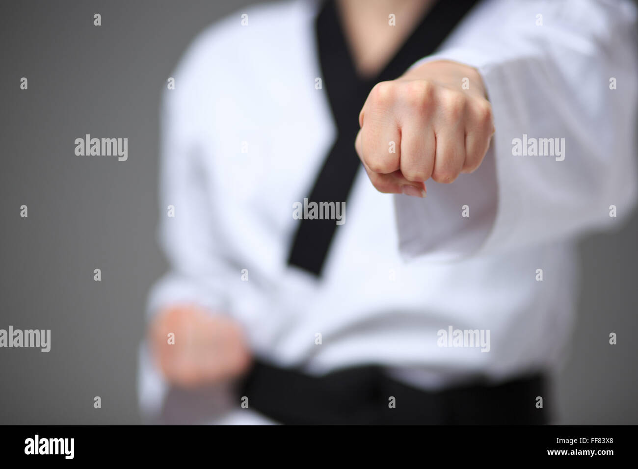 The hand of karate girl in white kimono and black belt training karate ...