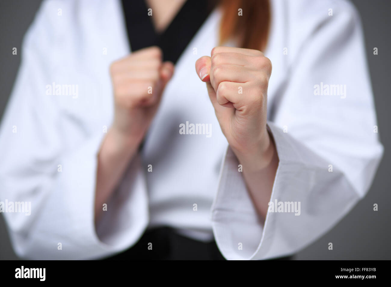 The hands of karate girl in white kimono and black belt training karate ...