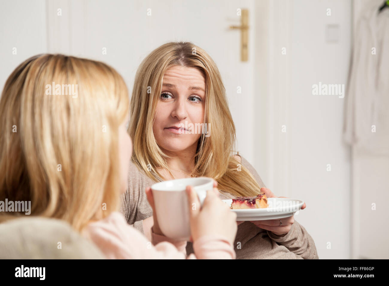 girlfriends in coffee gossip, one looks surprised Stock Photo - Alamy