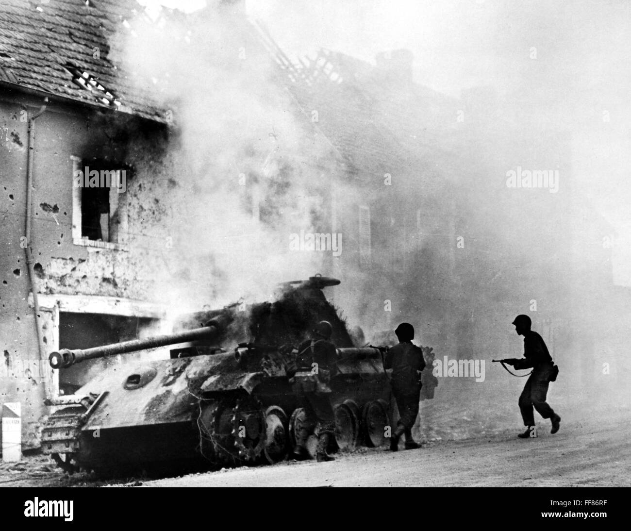 WORLD WAR II: NORMANDY. /nA burning German Giant Tiger tank surrounded ...