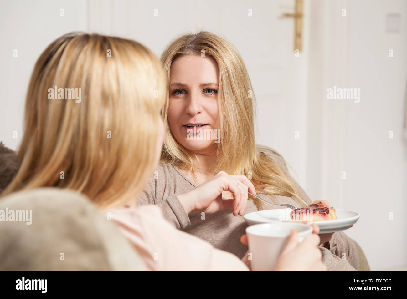 two blond woman in a coffee gossip Stock Photo - Alamy