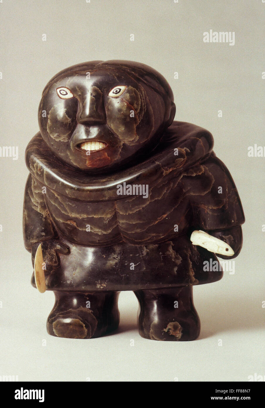 CANADIAN ESKIMO FIGURINE. /nFigurine of Eskimo woman holding fish and ...