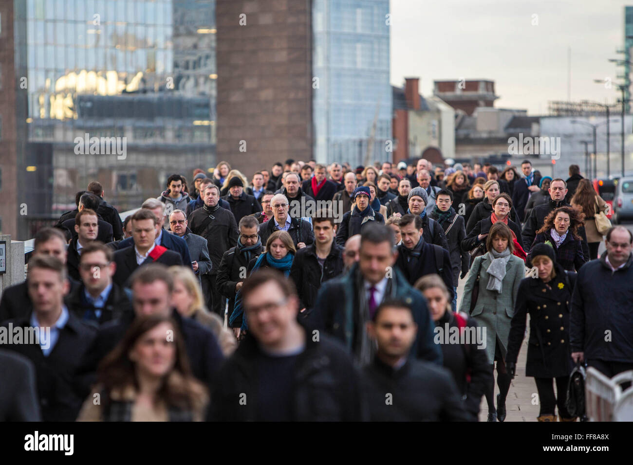 Commuters walk across London bridge to get to work in the City of ...