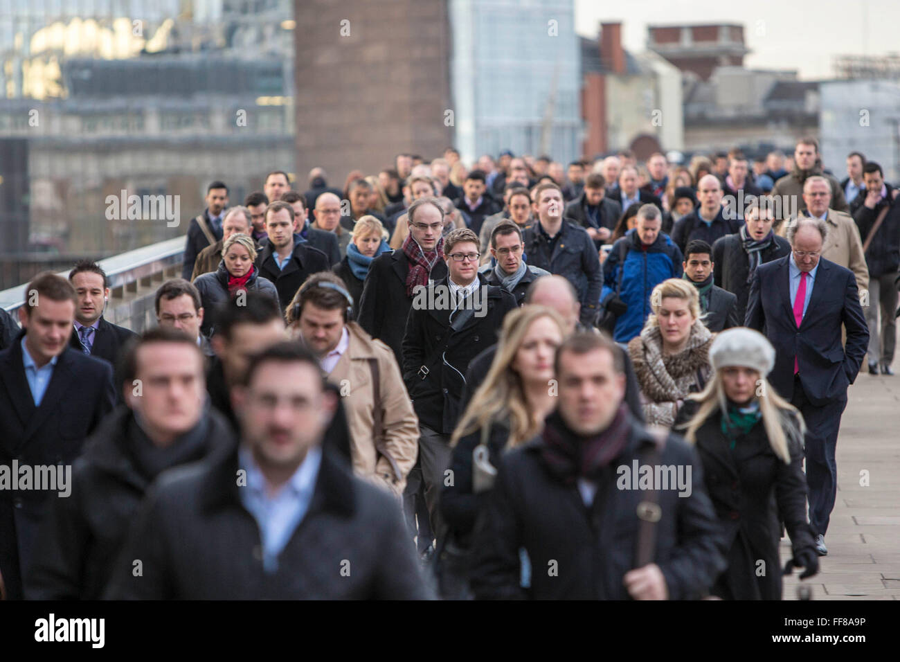 Commuters walk across London bridge to get to work in the City of ...