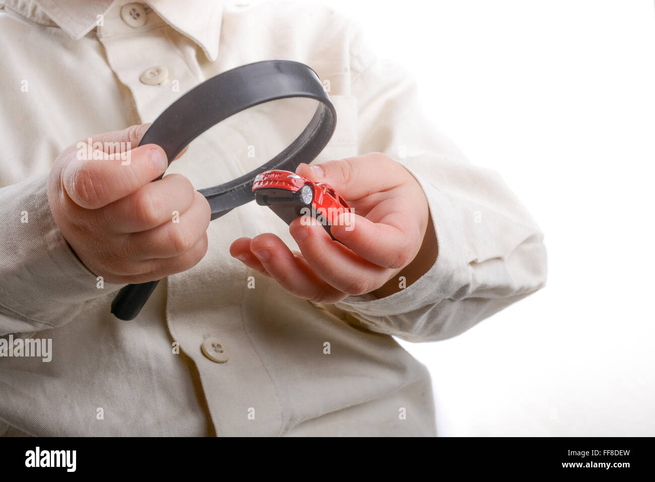 Baby holding a magnifying glass in hand on a white background Stock ...