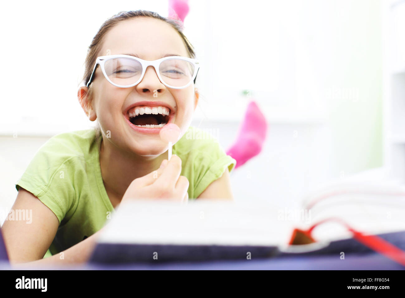 Teenager reading a book. Happy childhood, laughing girl. Reading is a ...