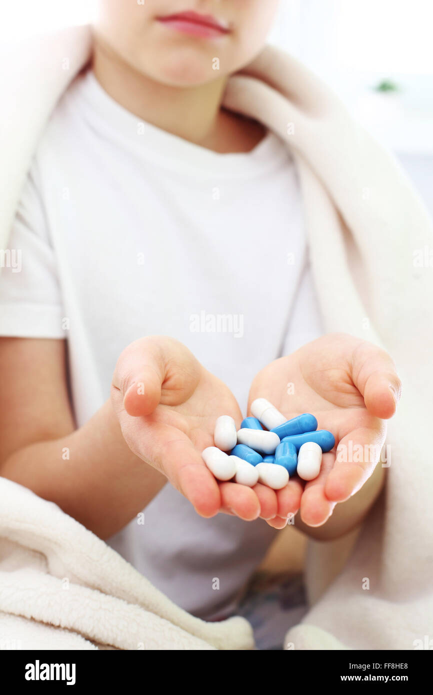 Colorful tablets, illness of a child. A lot of white and blue pills ...