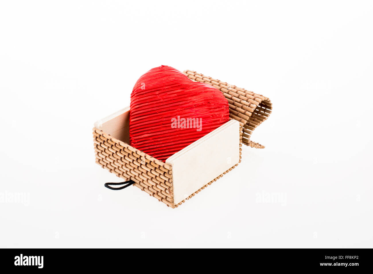 Red heart shaped object placed in a straw box on white background Stock ...