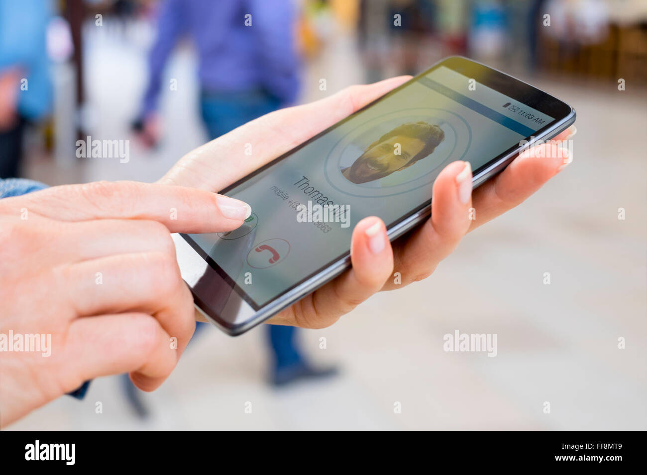 Woman answering mobile phone, calling a friend. Blur people background ...