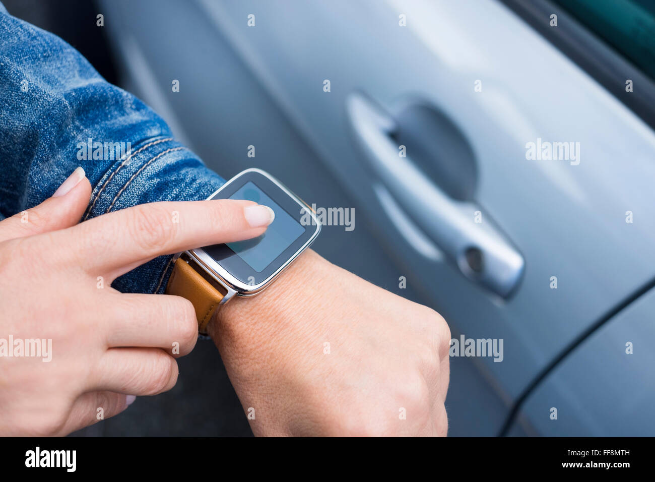 Woman connects to her car with smartwatch Stock Photo - Alamy