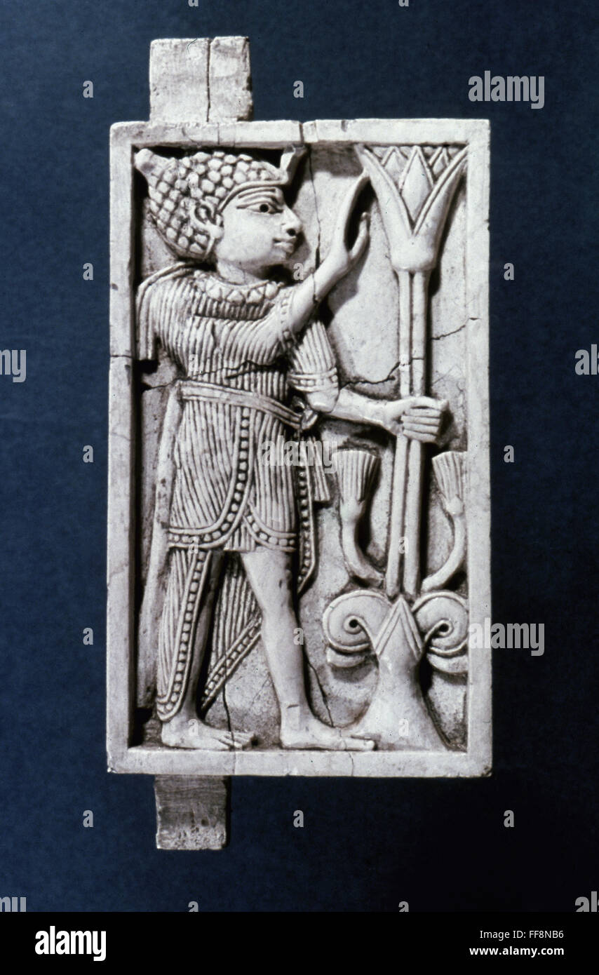 ASSYRIAN IVORY PANEL. /nCarved ivory panel with a youth grasping a ...
