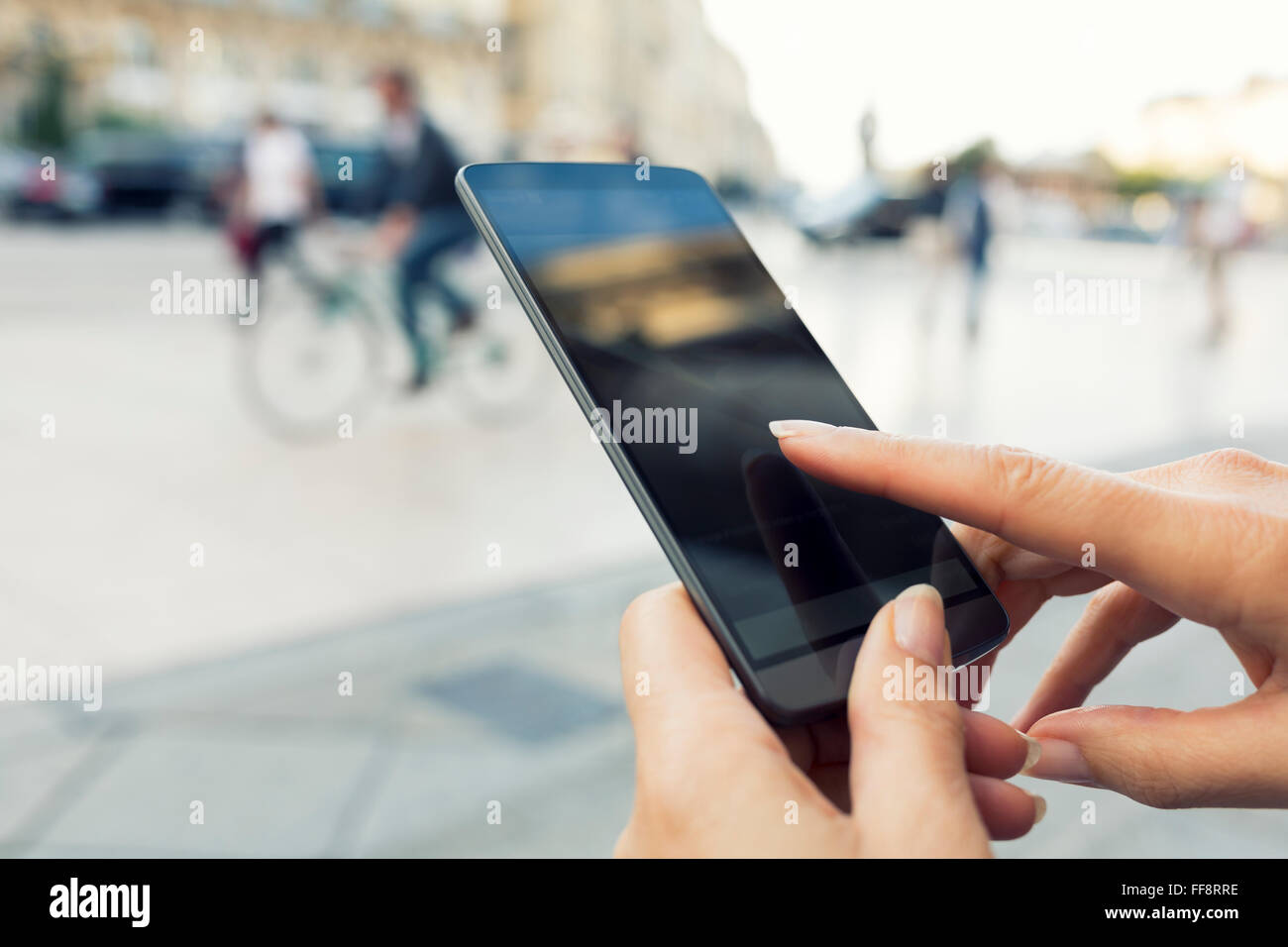 Female in the city using her cell phone. Blur Downtown background Stock ...