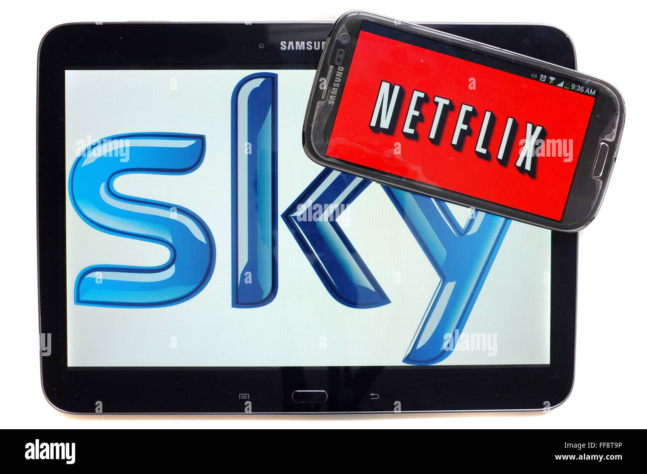 The Netflix logo on a smartphone screen on top of a tablet displaying ...