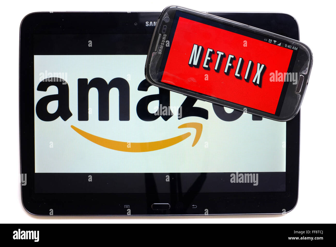 The Netflix logo on a smartphone screen on top of a tablet displaying ...