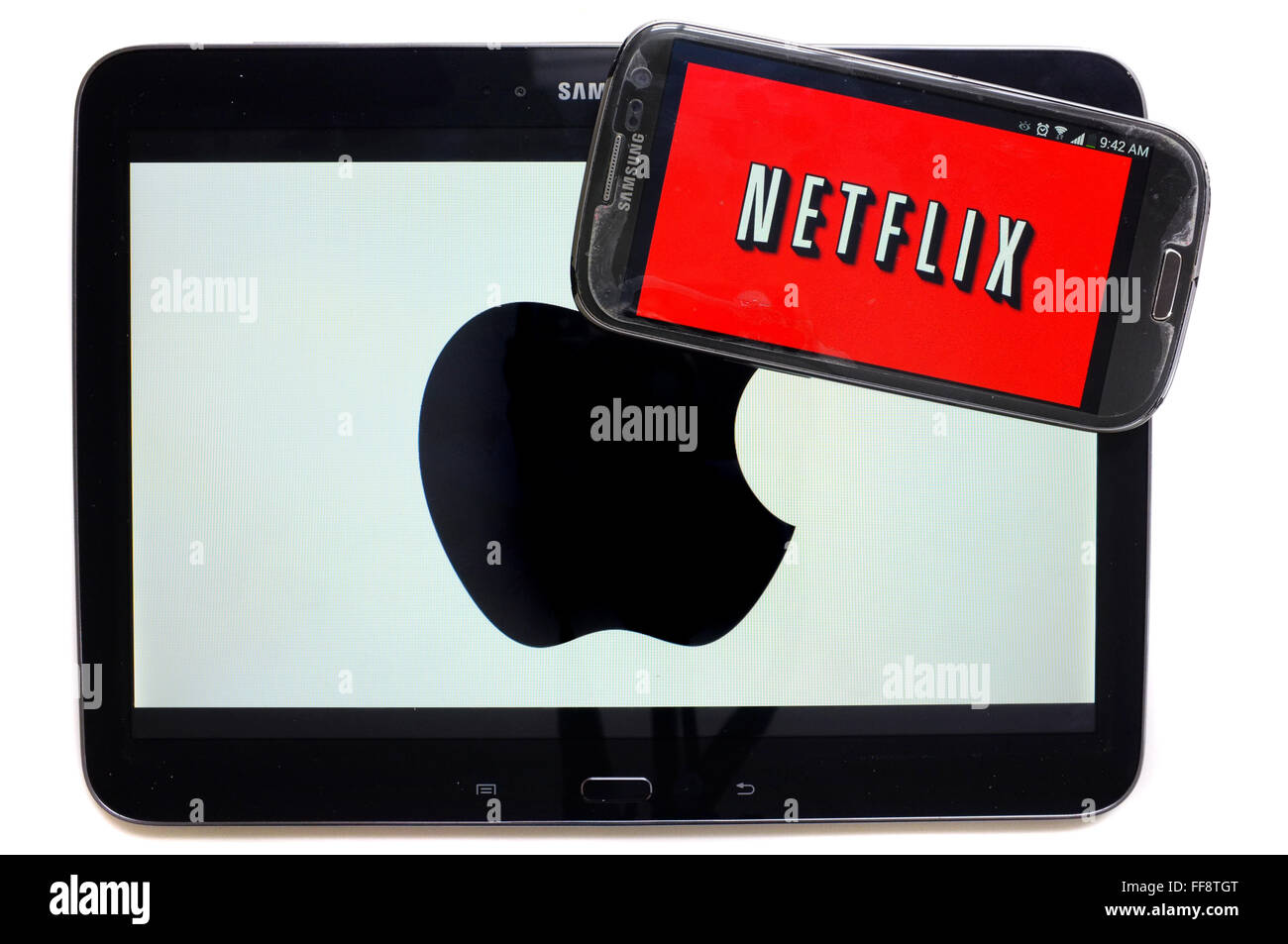 The Netflix logo on a smartphone screen on top of a tablet displaying ...