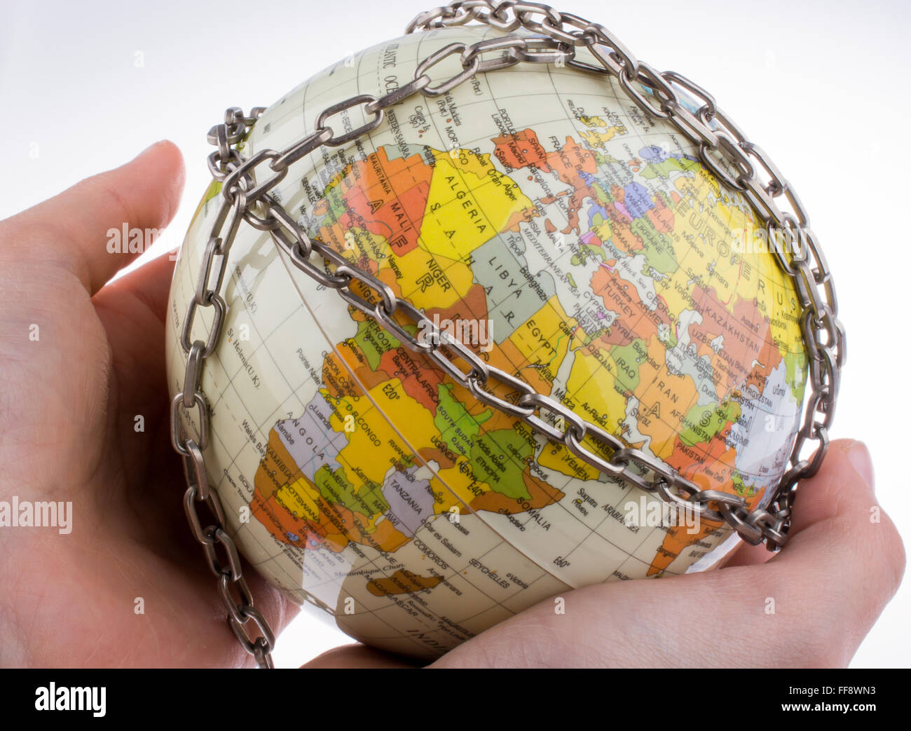 Hand holding a globe in chains Stock Photo - Alamy