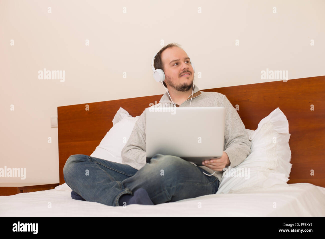 man in bed working with a laptop Stock Photo - Alamy