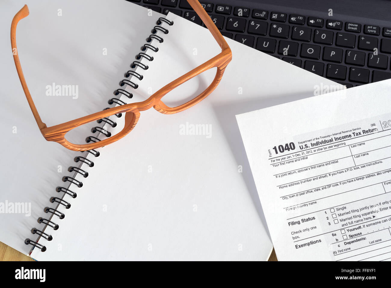 Office desk table with Laptop computer, eyegglass, 1040 taxform on ...