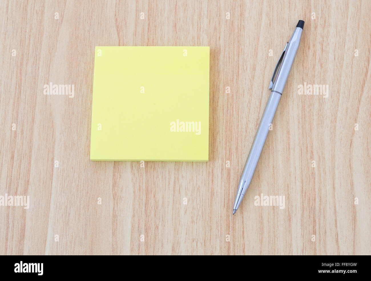 Blank yellow notepad with pen on office wooden table Stock Photo - Alamy
