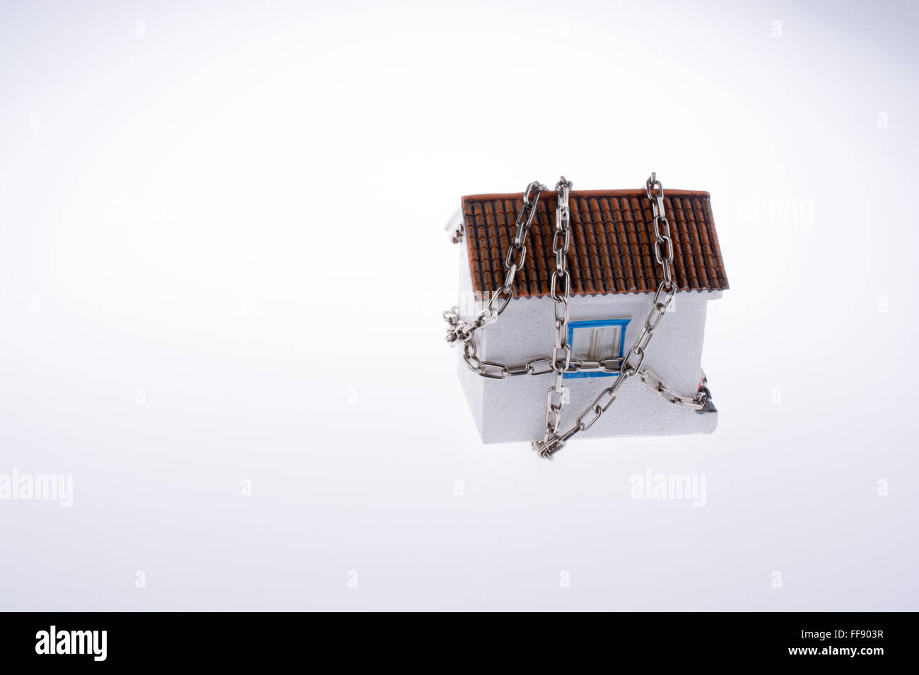 house in chains on a white background Stock Photo - Alamy