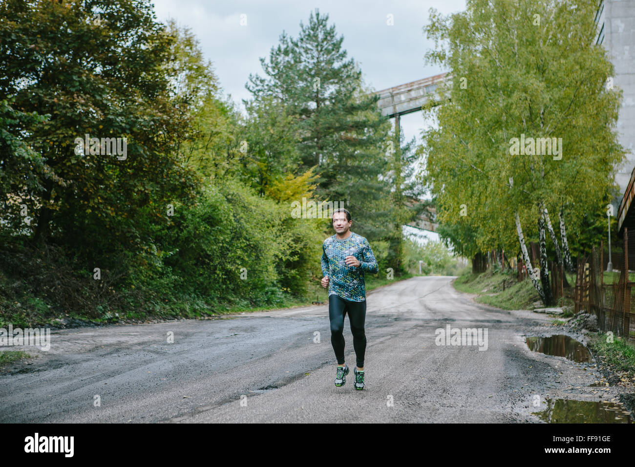 Man running on an old road in green nature Stock Photo - Alamy