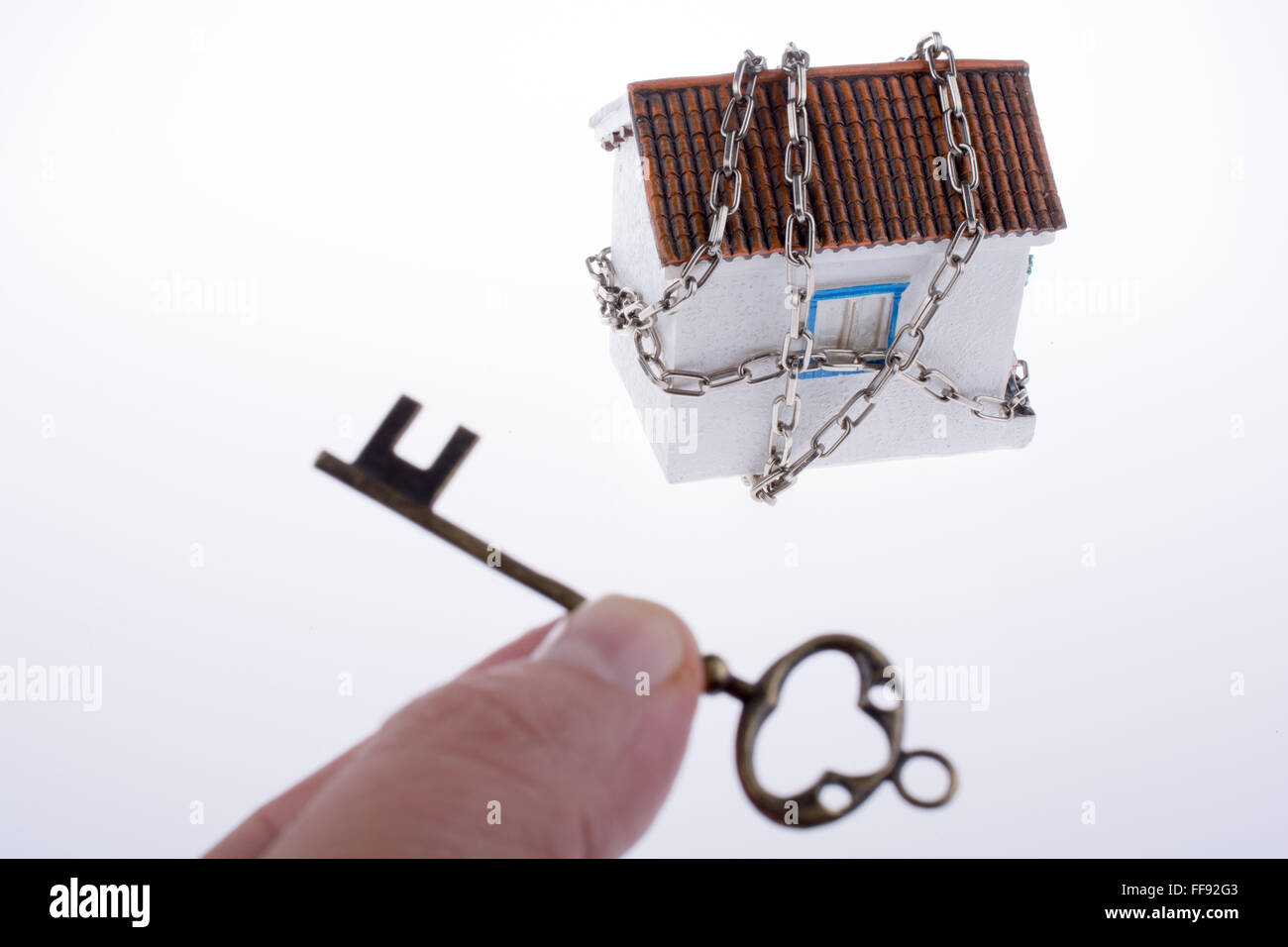 key and a house in chains on a white background Stock Photo - Alamy