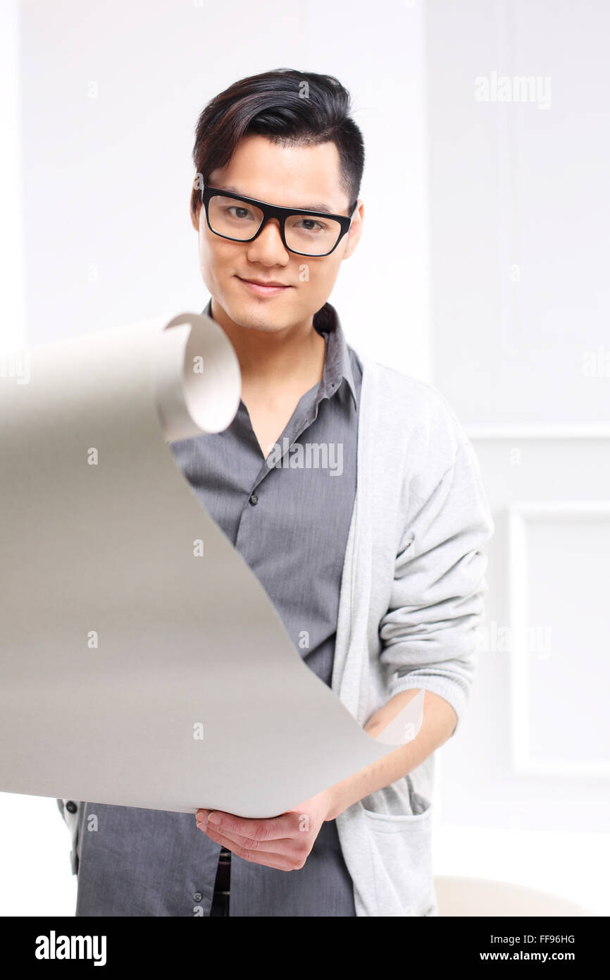 Handsome man while working on a project sitting behind a desk and ...