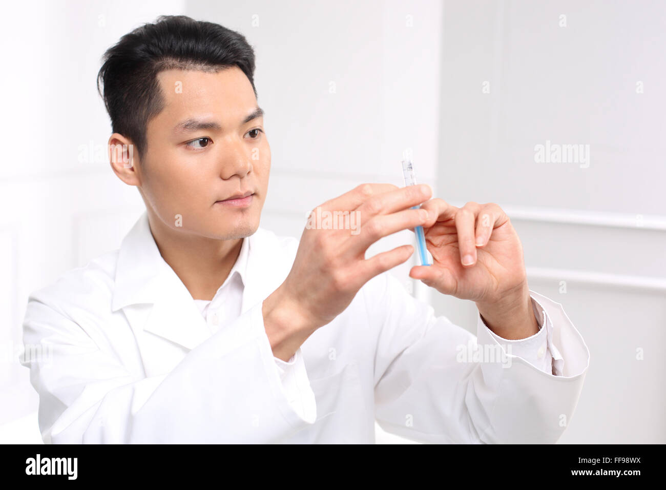 Medical doctor preparing an injection, Handsome doctor in white coat ...