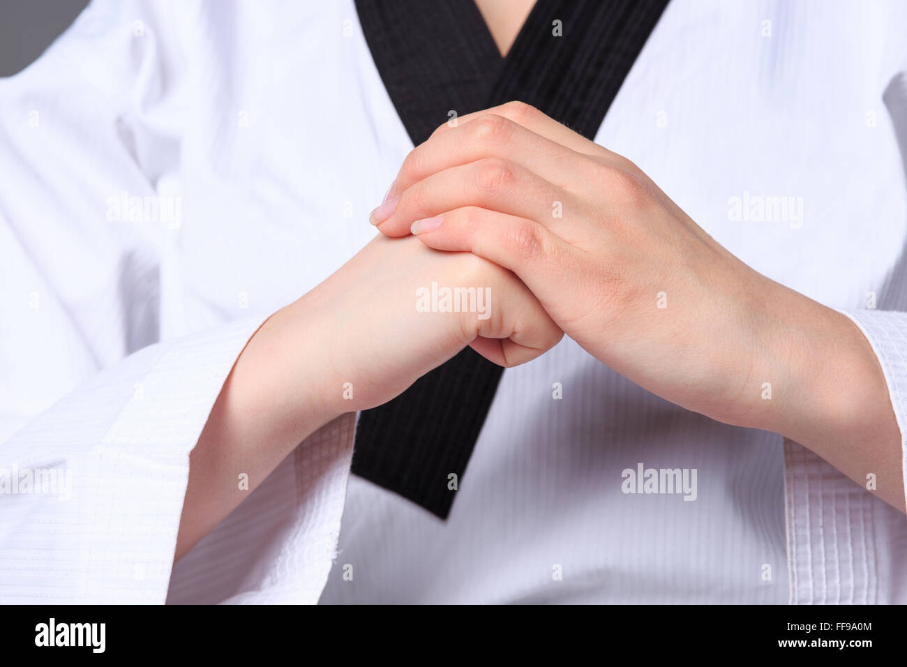 The hands of karate girl in white kimono and black belt training karate ...