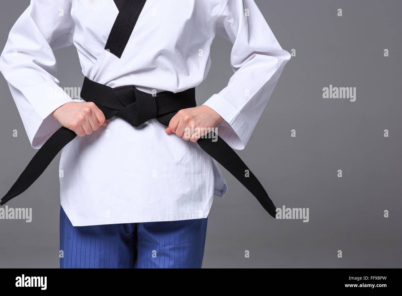 The hands of karate girl in white kimono and black belt training karate ...