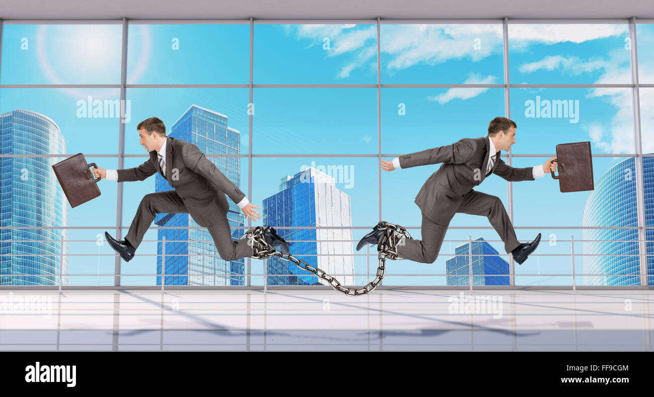 Two businessmen linked chain running Stock Photo - Alamy